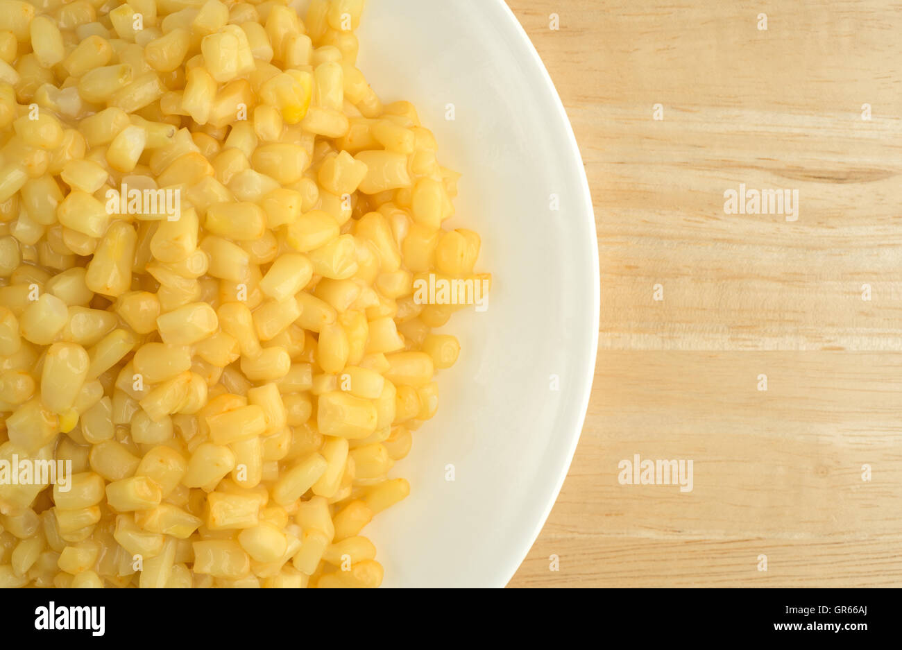 Top close view of shoepeg white corn with a butter sauce on a white ...