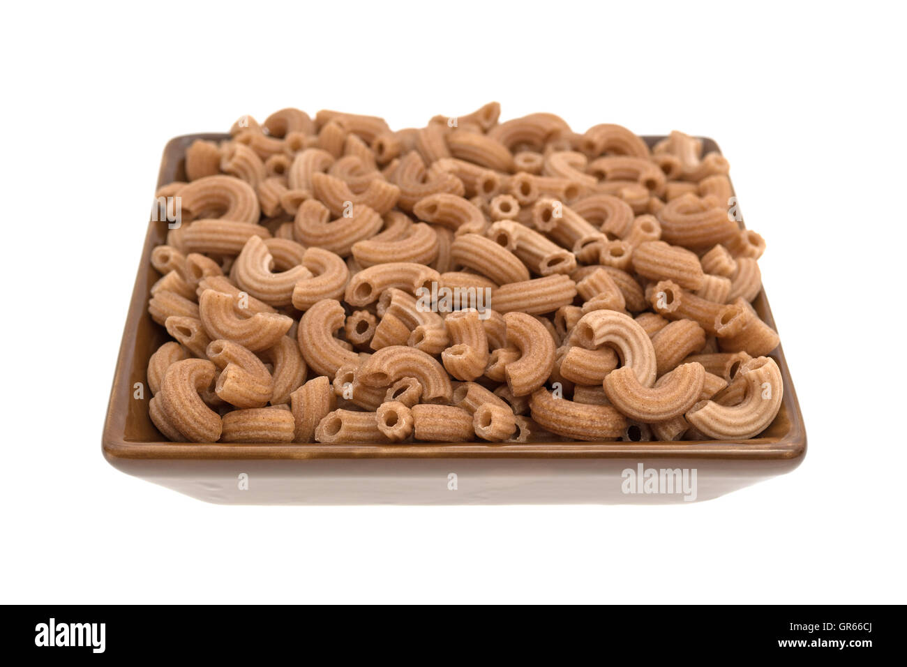 A portion of red rice elbow shaped pasta in a brown square dish ...