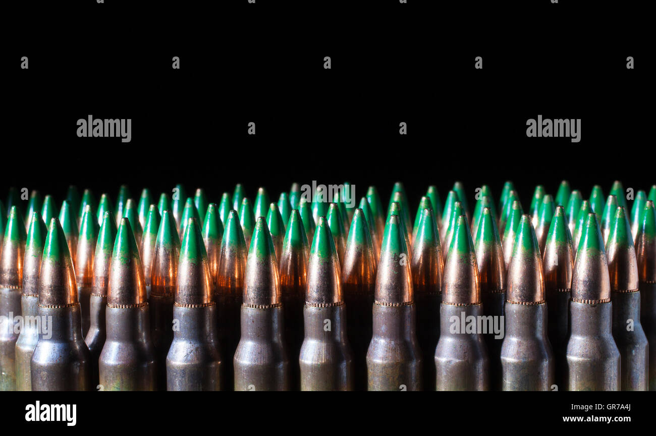 Bullets with green tips on rifle cartridges and a black background ...