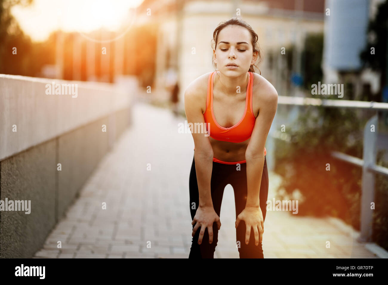 Tired female jogger resting after finishing run Stock Photo - Alamy