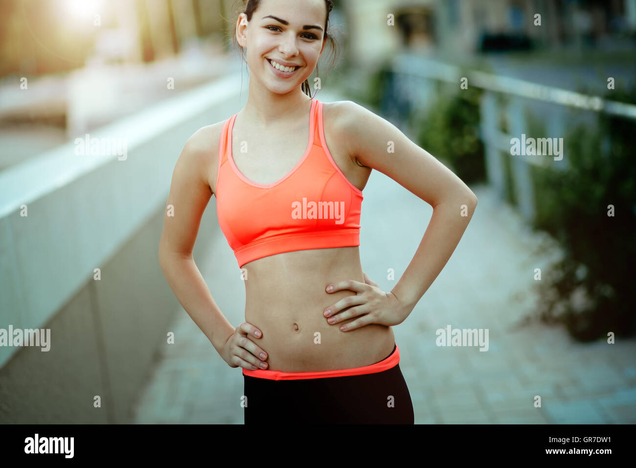 Happy sporty female jogger smiling Stock Photo - Alamy