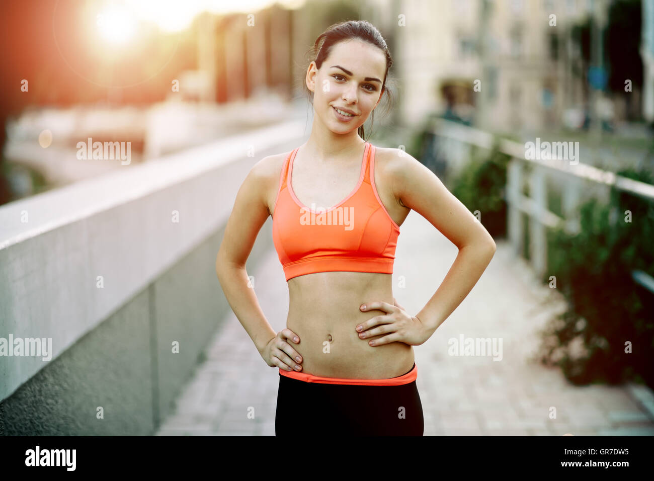 Happy sporty female jogger smiling Stock Photo - Alamy