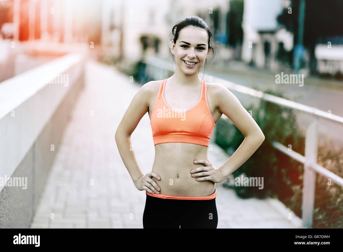 Happy sporty female jogger smiling Stock Photo - Alamy
