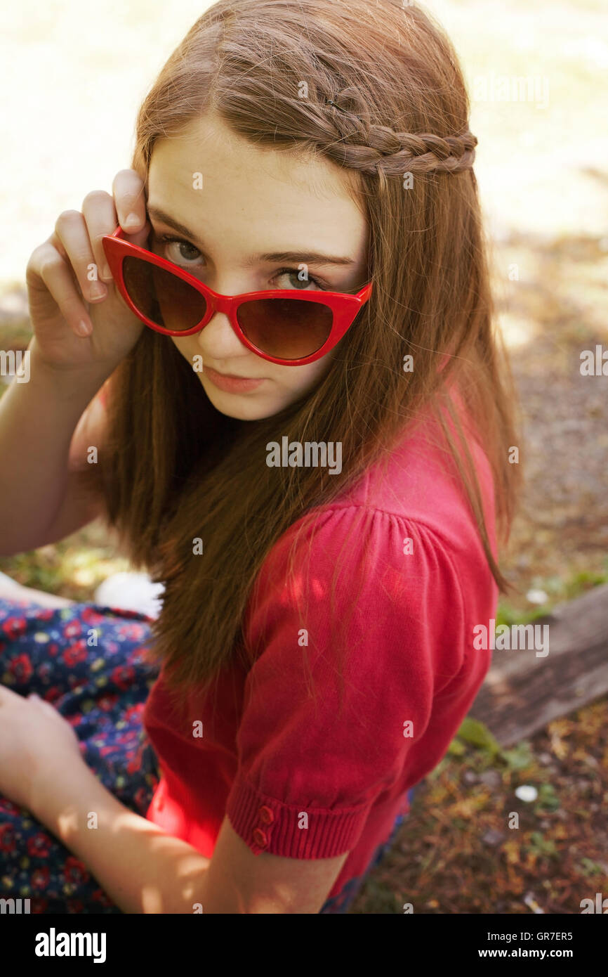 Beautiful teenage girl wearing red retro sunglasses Stock Photo - Alamy