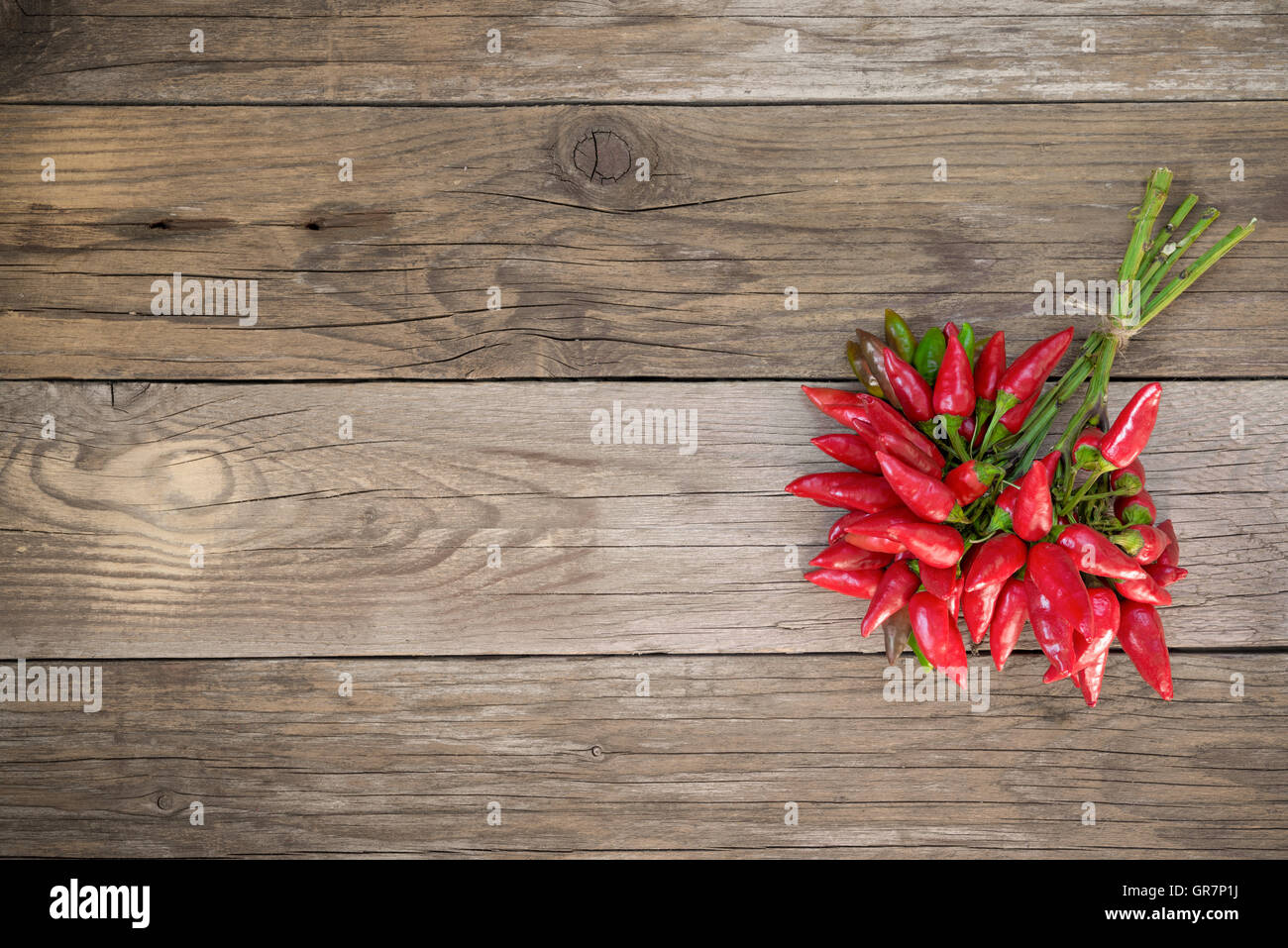 Bunch of red hot chili pepper on wooden table Stock Photo - Alamy