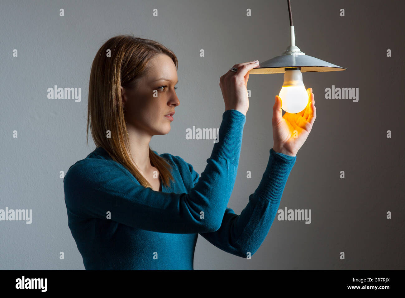 Young Woman With A Light Bulb Stock Photo - Alamy