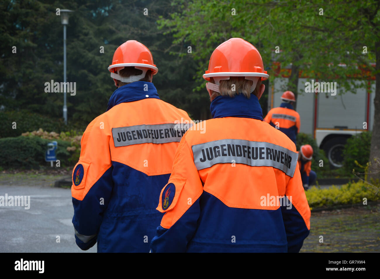 Two Young Fireman In Uniform Standing On The Road Stock Photo - Alamy