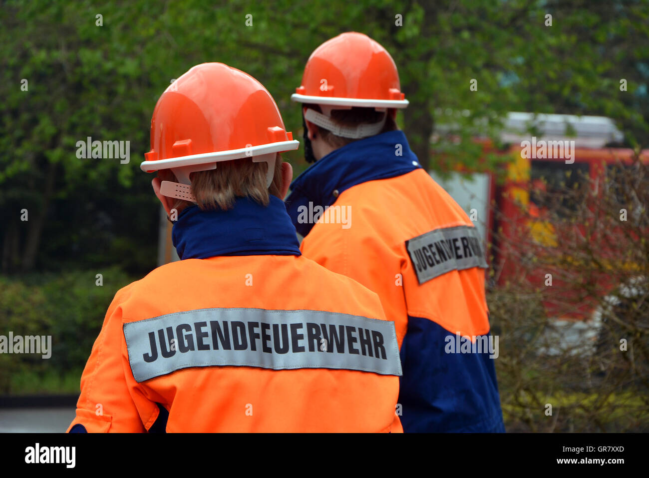 Two Young Fireman In Uniform Standing On The Road Stock Photo - Alamy