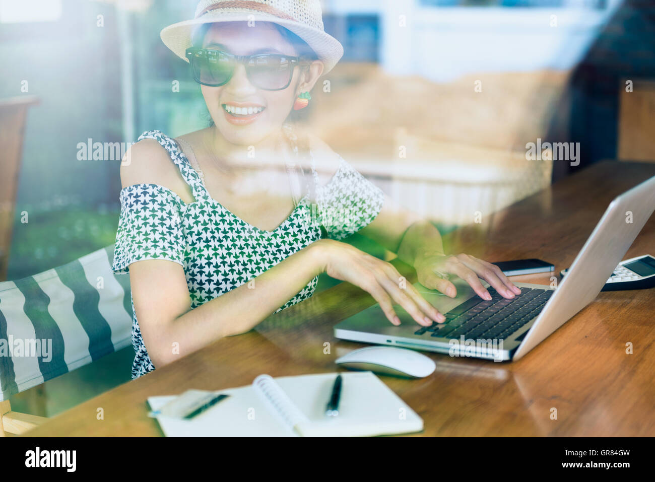 Young woman enjoying working sitting near window in the coffee shop ...