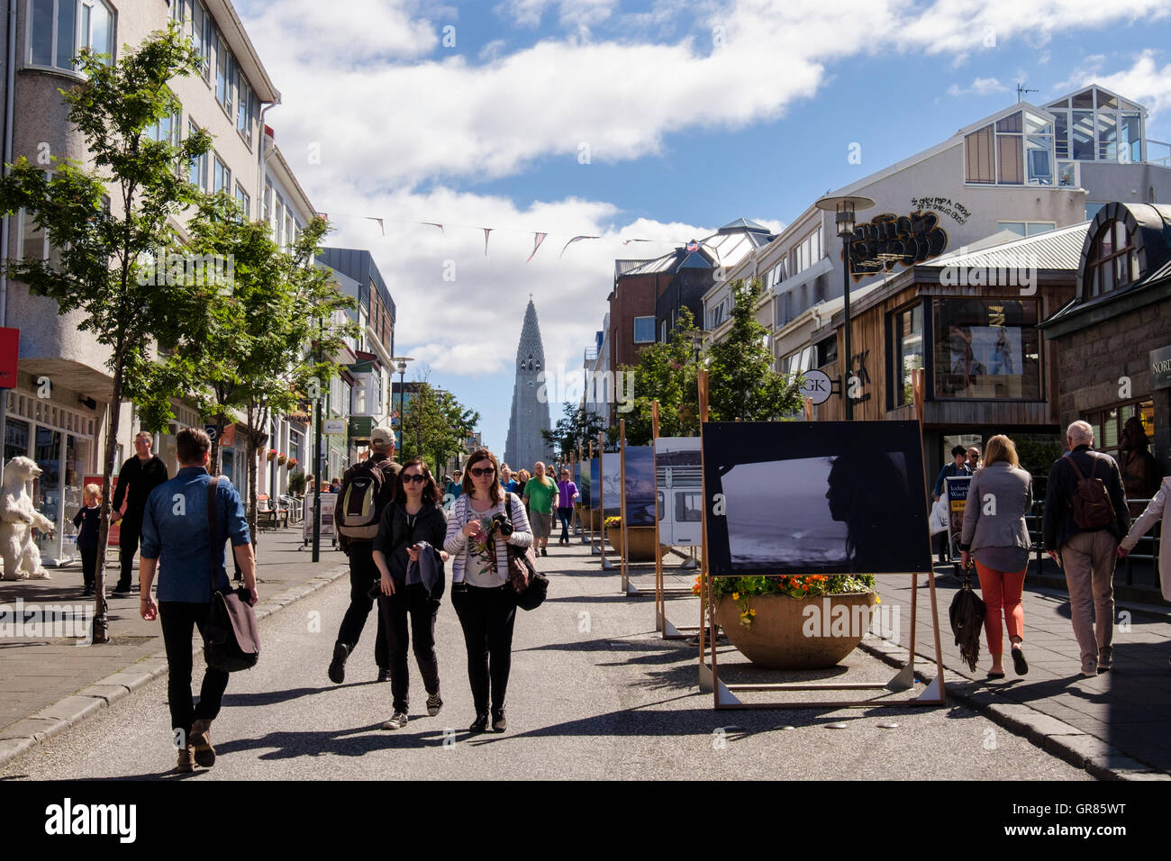 Busy street scene with paintings on display and Lutheran Parish Church ...