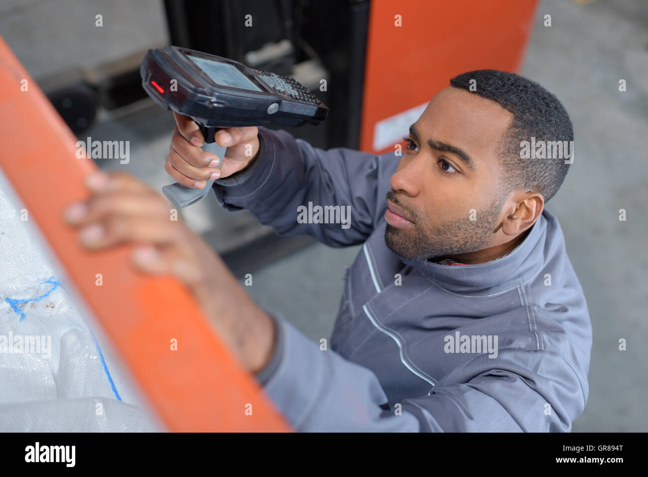 Man in warehouse using electronic scanner Stock Photo - Alamy