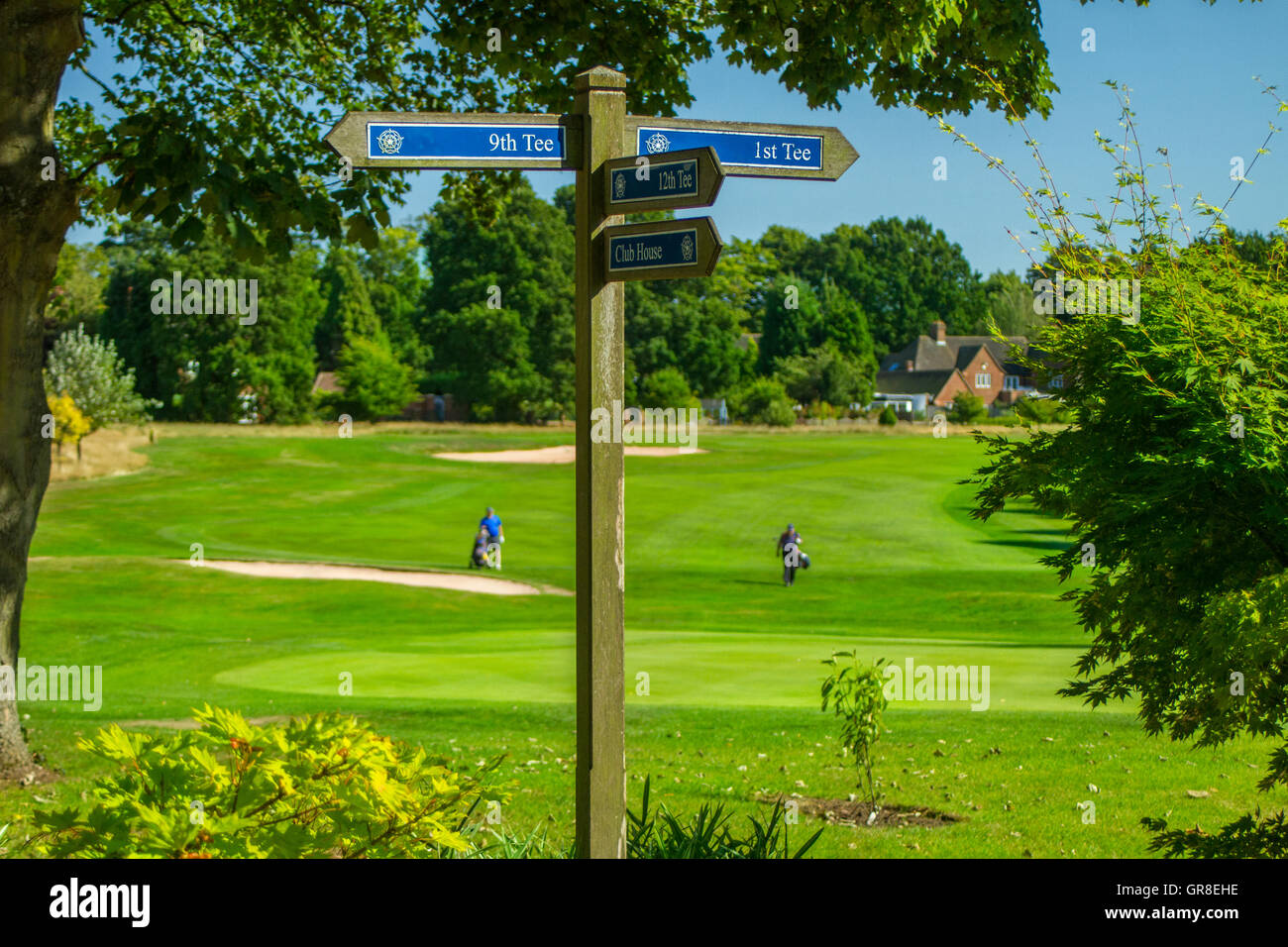 Golf course signage showing 1st Tee and Club House with golfers in the ...
