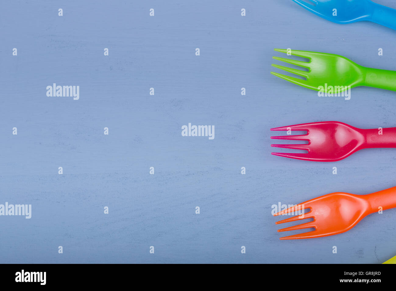 Kids forks. Composition of Colorful forks on a blue wooden table Stock ...