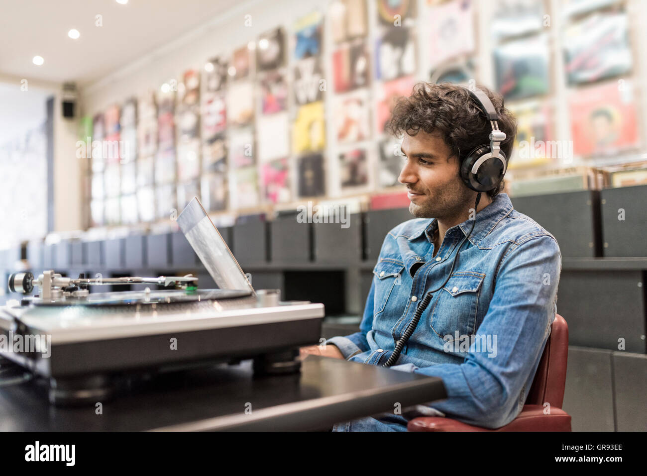 Young handsome man listening a record in the vinyl record store Stock ...