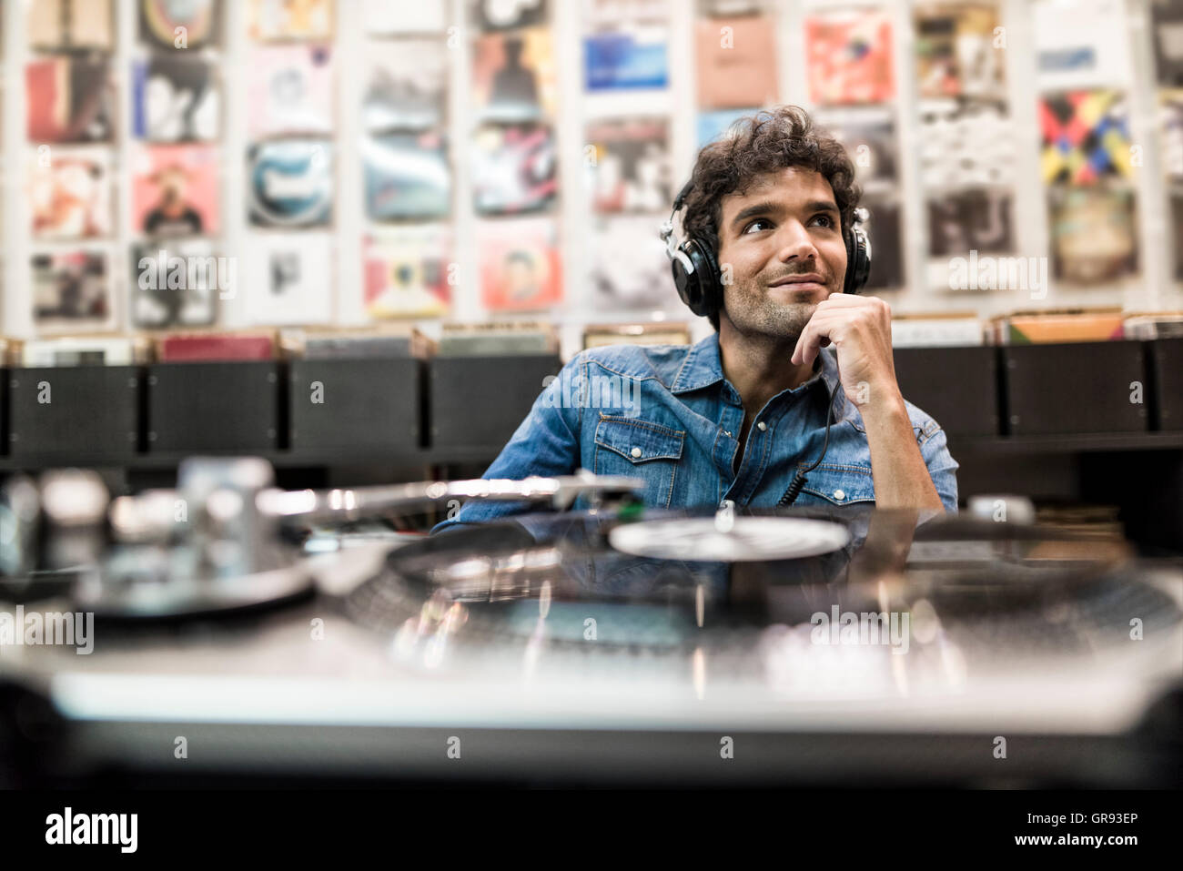 Young handsome man listening a record in the vinyl record store Stock ...