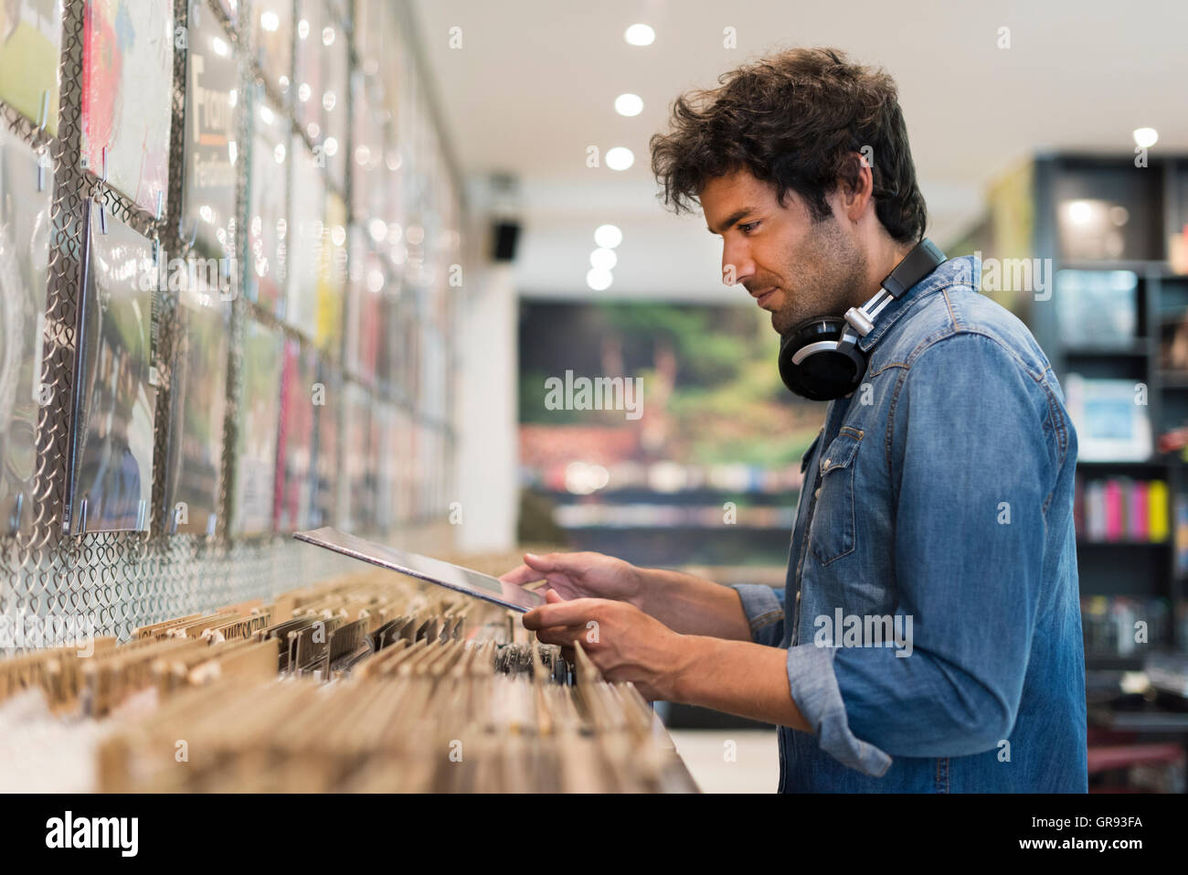 Man browsing vinyl album in a record store Stock Photo - Alamy