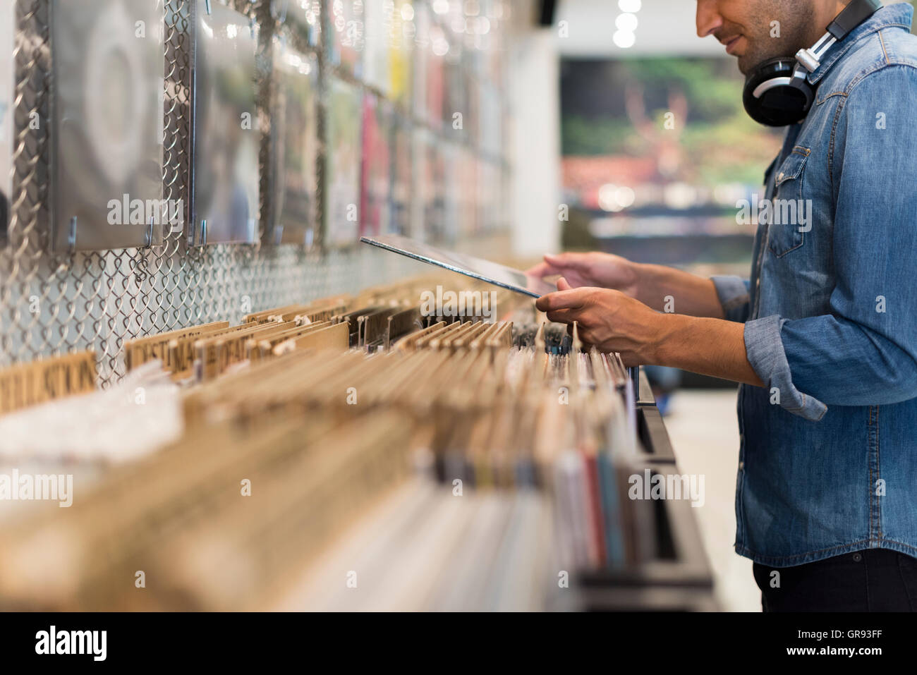 Man browsing vinyl album in a record store Stock Photo - Alamy