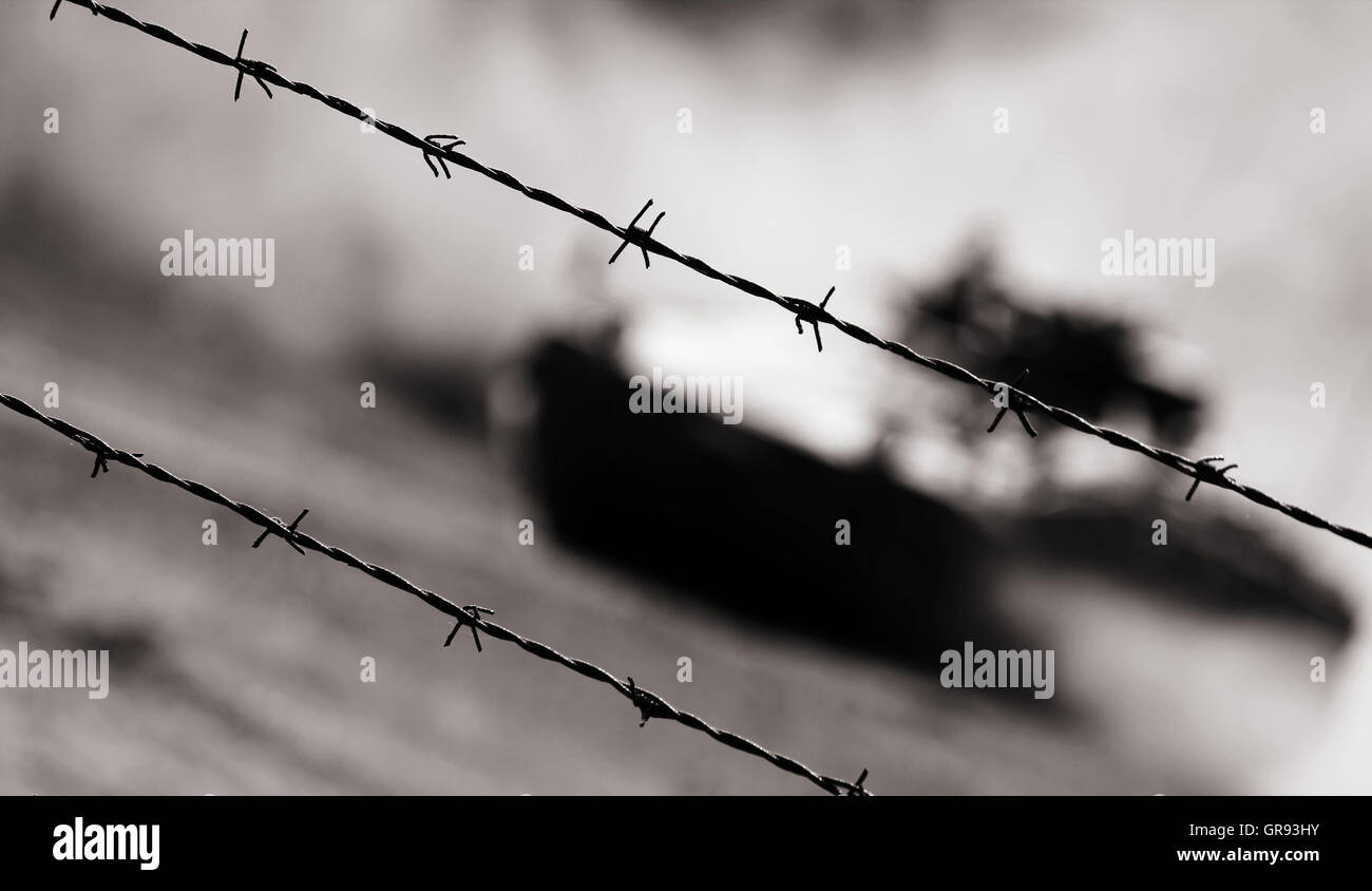 Barbed Wire With Tanks In The Background Stock Photo - Alamy