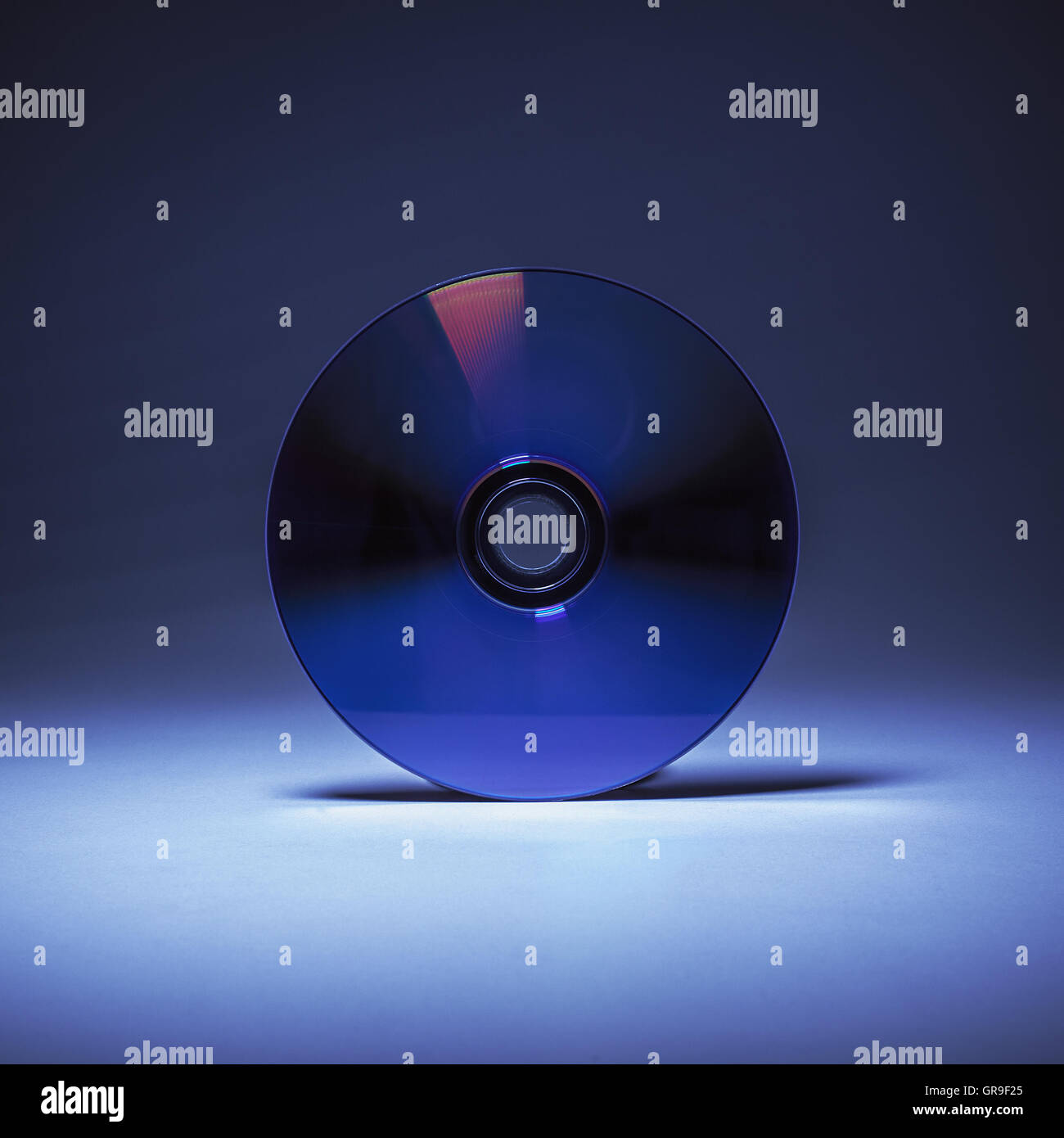 Simple composition, closeup view of a compact disk in blue background ...