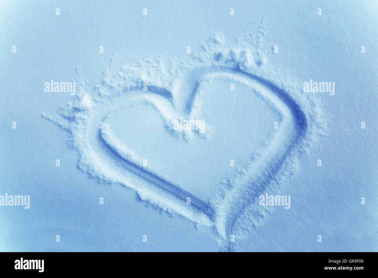 heart in snow, drawing in the snow. Light blue background Stock Photo ...
