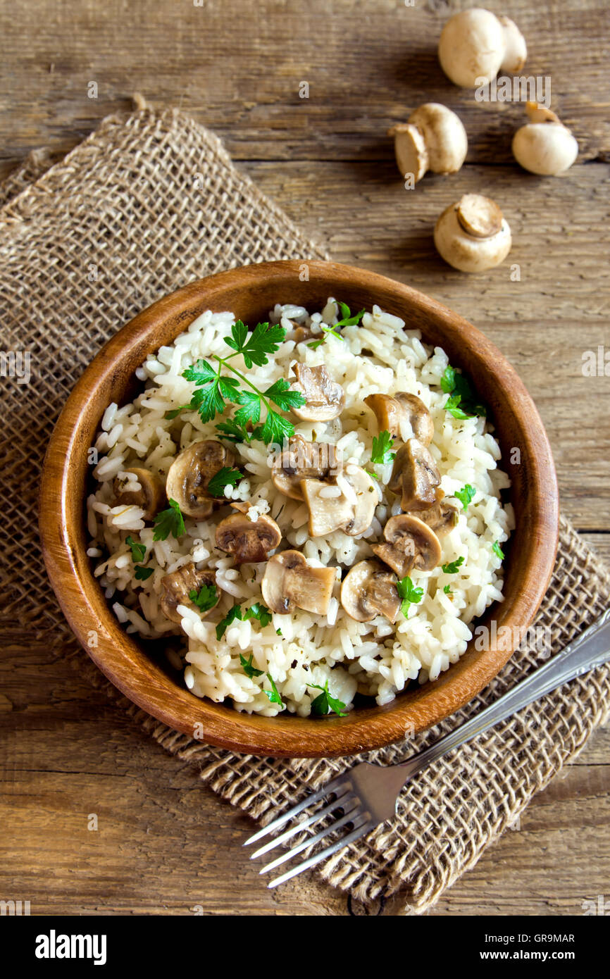 Mushroom risotto with parsley in wooden bowl close up Stock Photo - Alamy