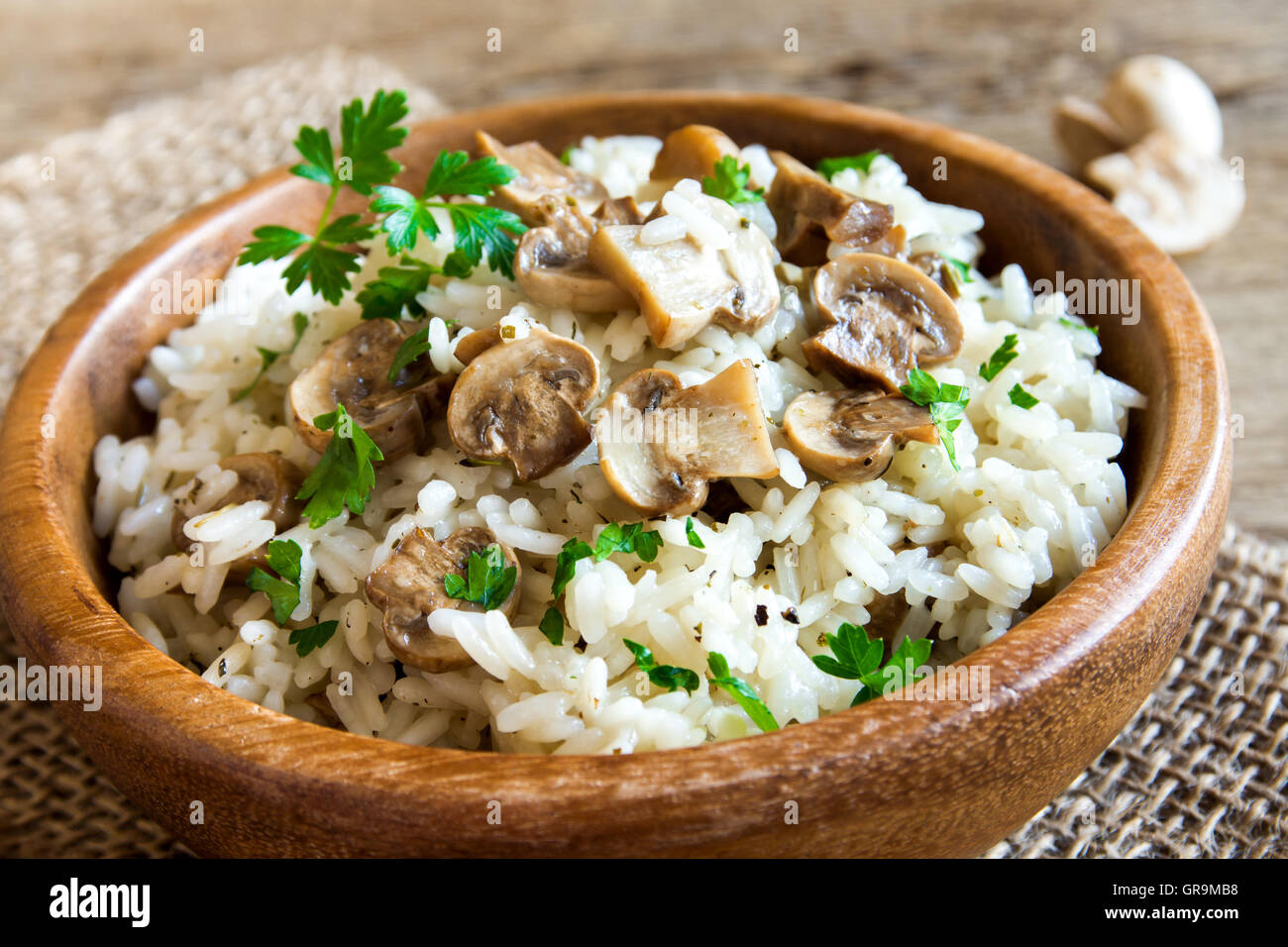 Mushroom risotto with parsley in wooden bowl close up Stock Photo - Alamy