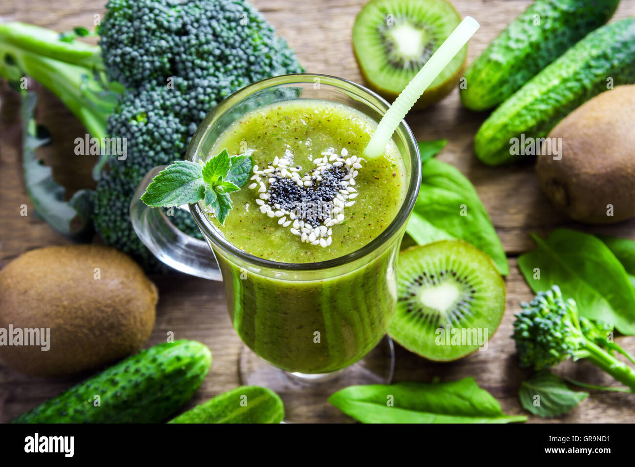 Green vegetable and herbs smoothie with heart of poppy and sesame seeds ...