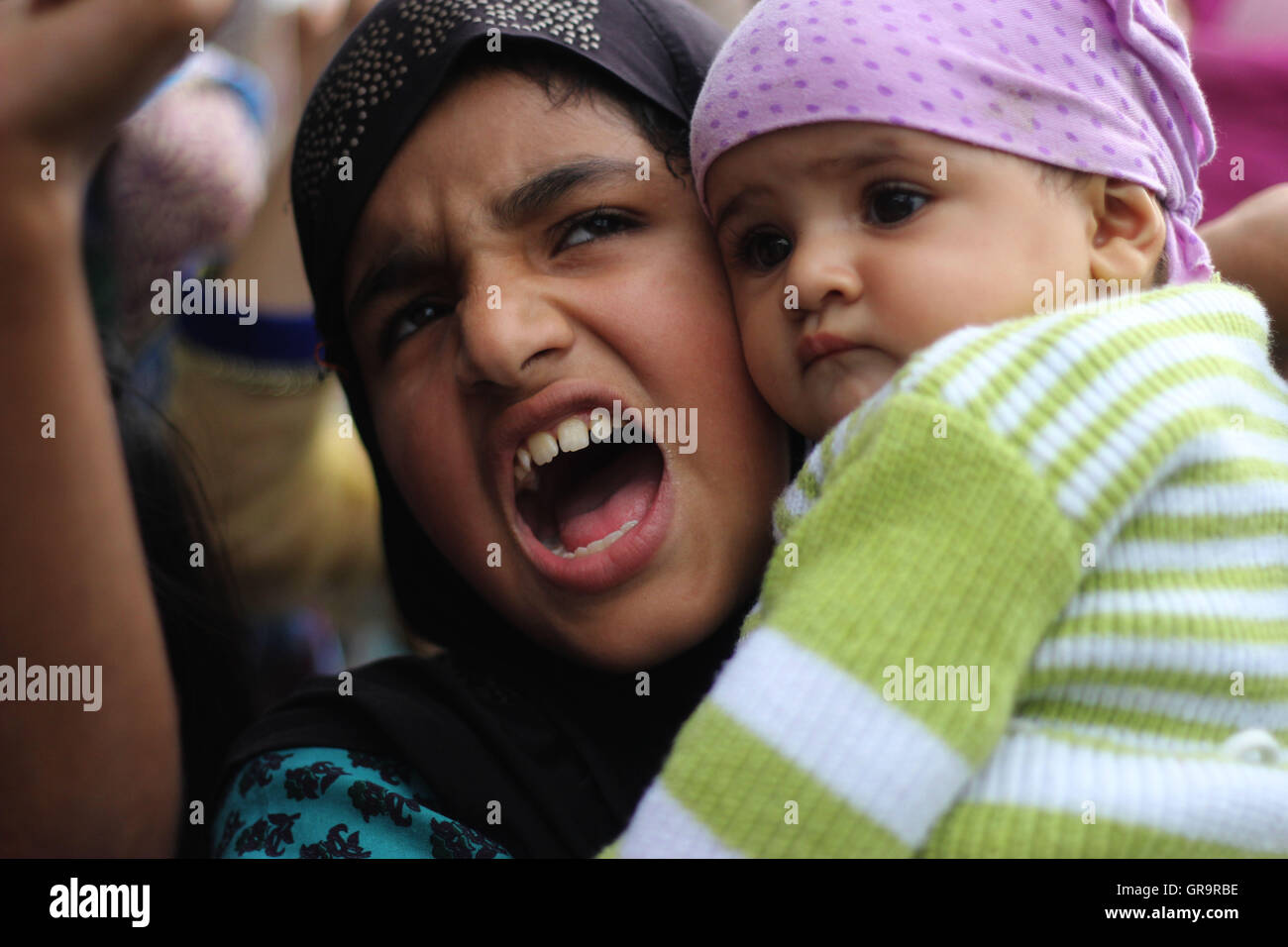 Srinagar, India. 06th Sep, 2016. A little girl holding a baby, shouting ...