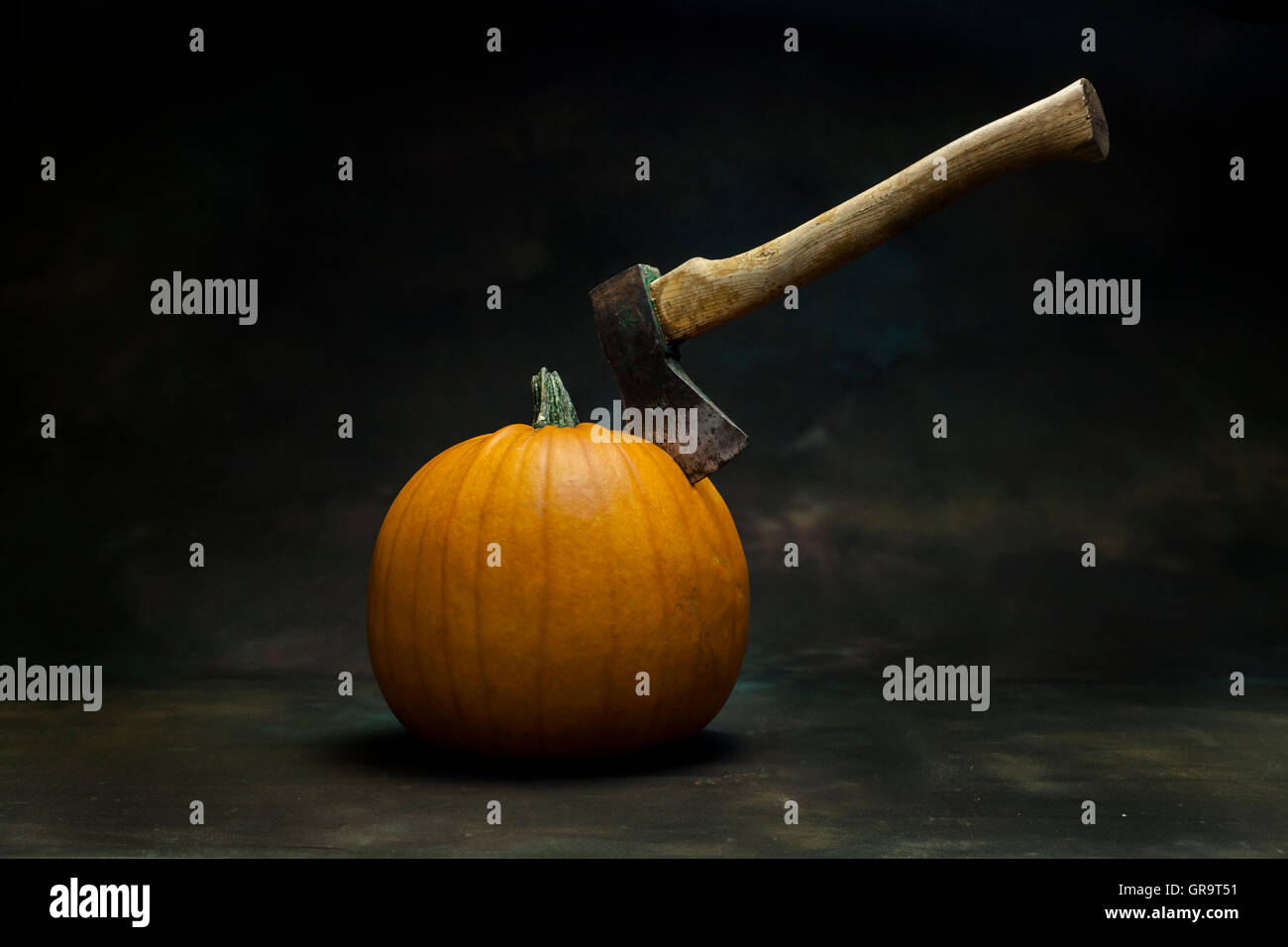 halloween photo with an orange pumpkin in a studio in dark sorrounding ...
