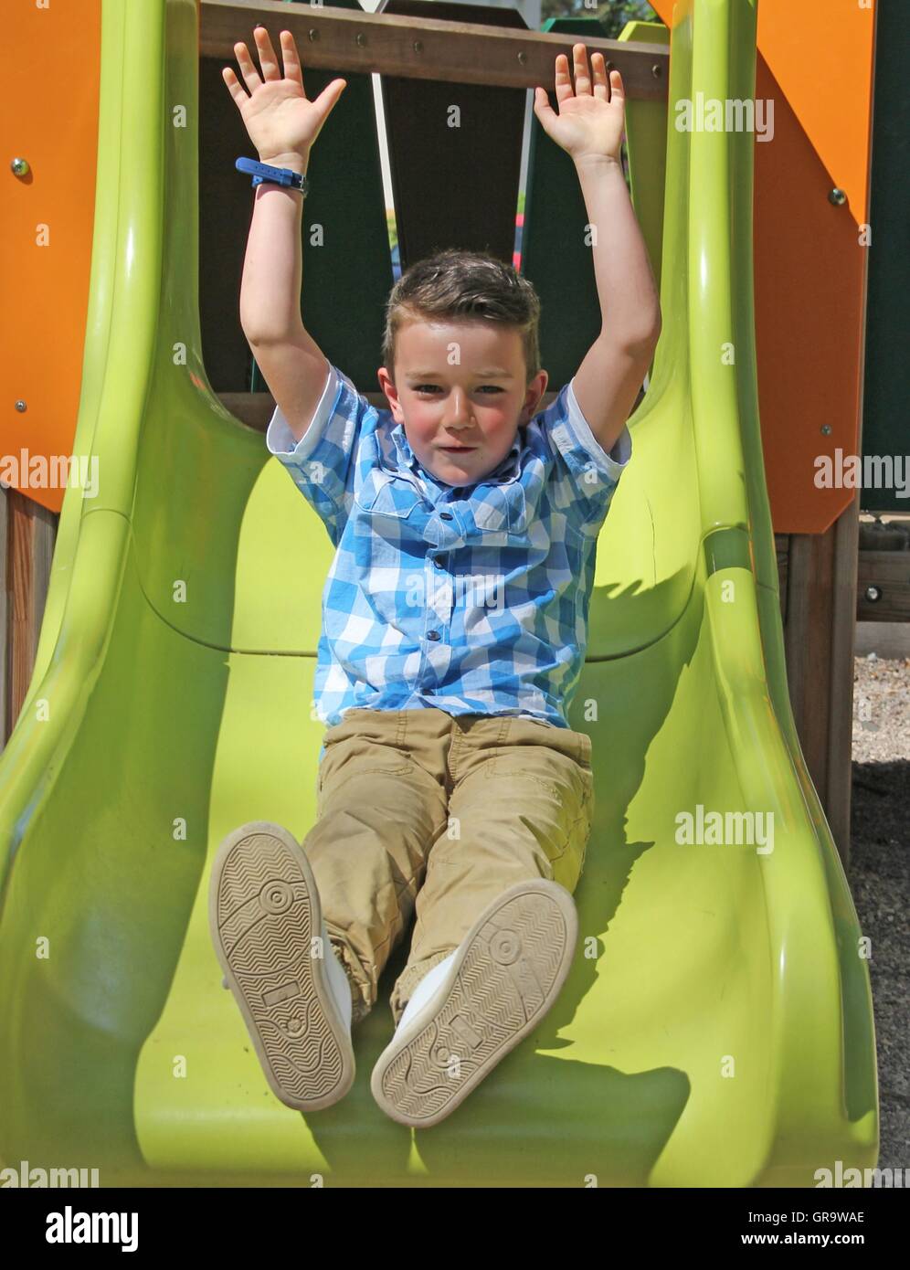 Boy On A Slide While Playing Stock Photo - Alamy
