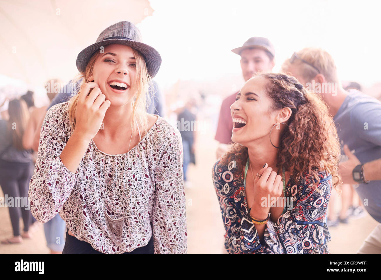 Young women laughing at music festival Stock Photo - Alamy