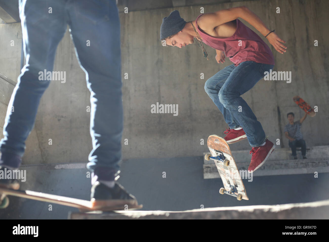 Teenage boy flipping skateboard at skate park Stock Photo - Alamy