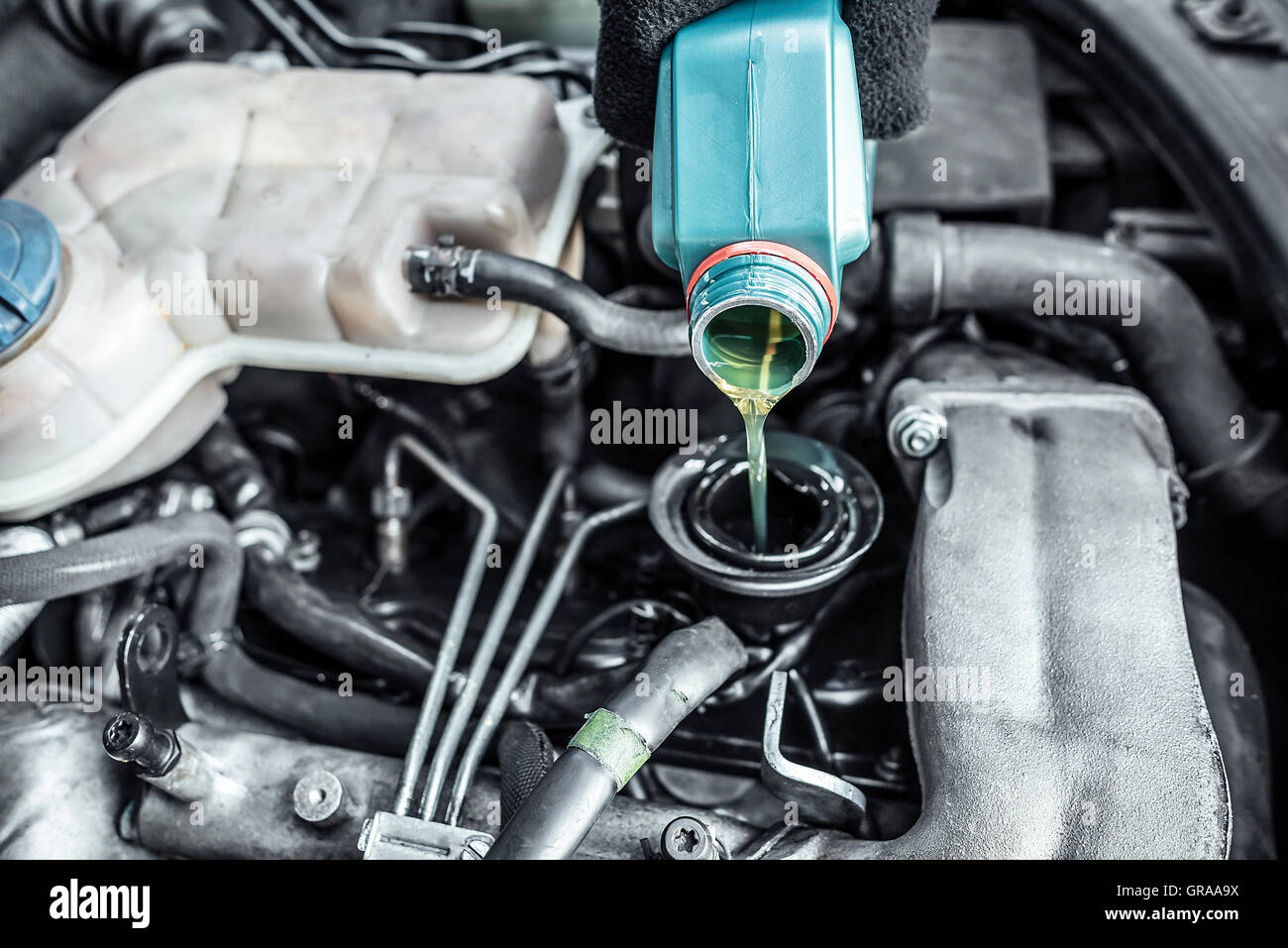 Automaster top up the oil in a car engine. Toned photo Stock Photo - Alamy