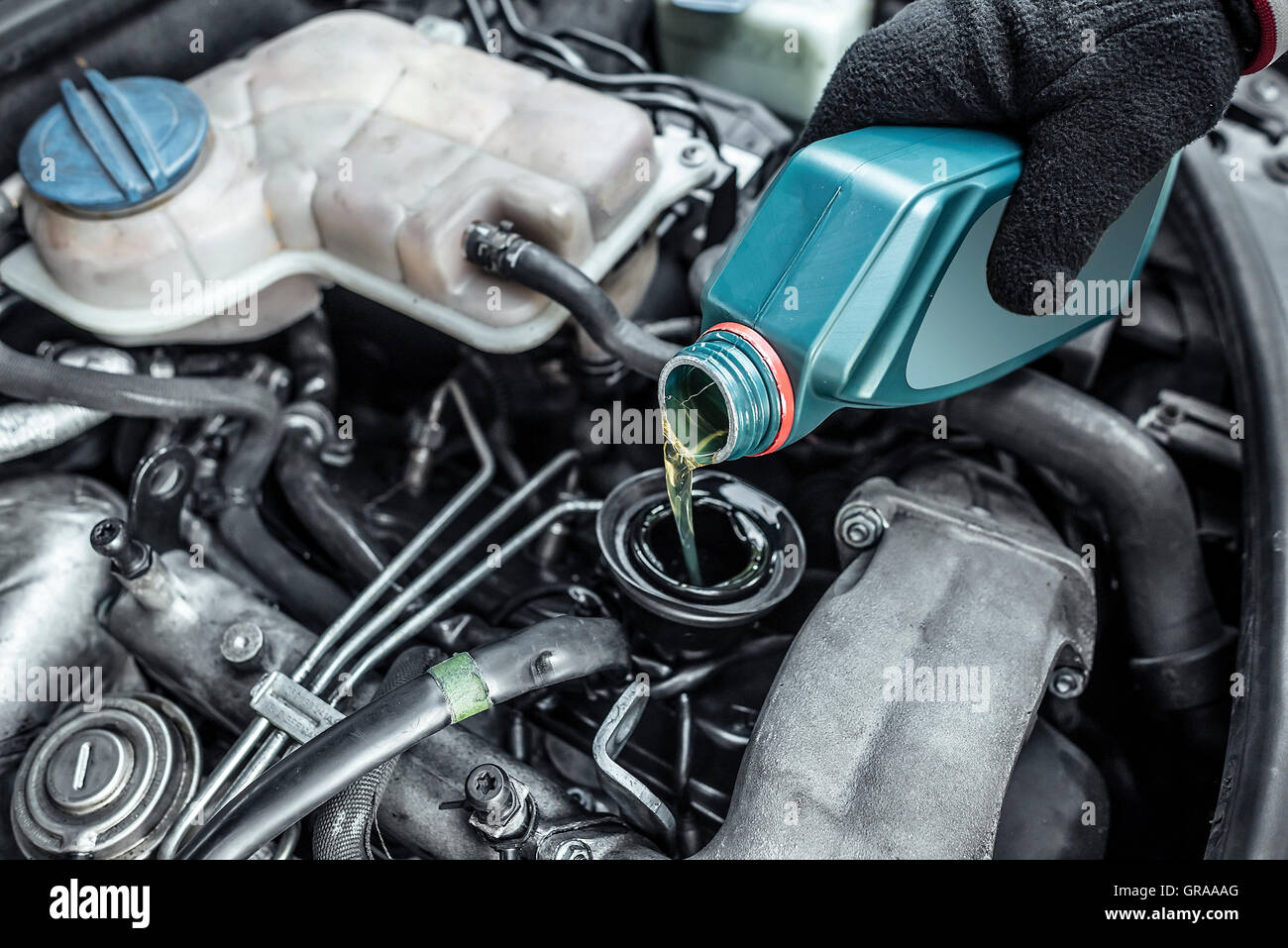 Automaster top up the oil in a car engine. Toned photo Stock Photo - Alamy