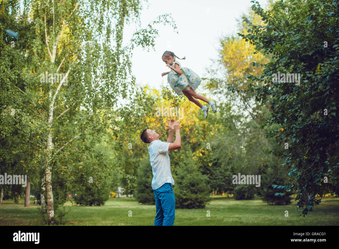 Father throws up his daughter in a park Stock Photo - Alamy