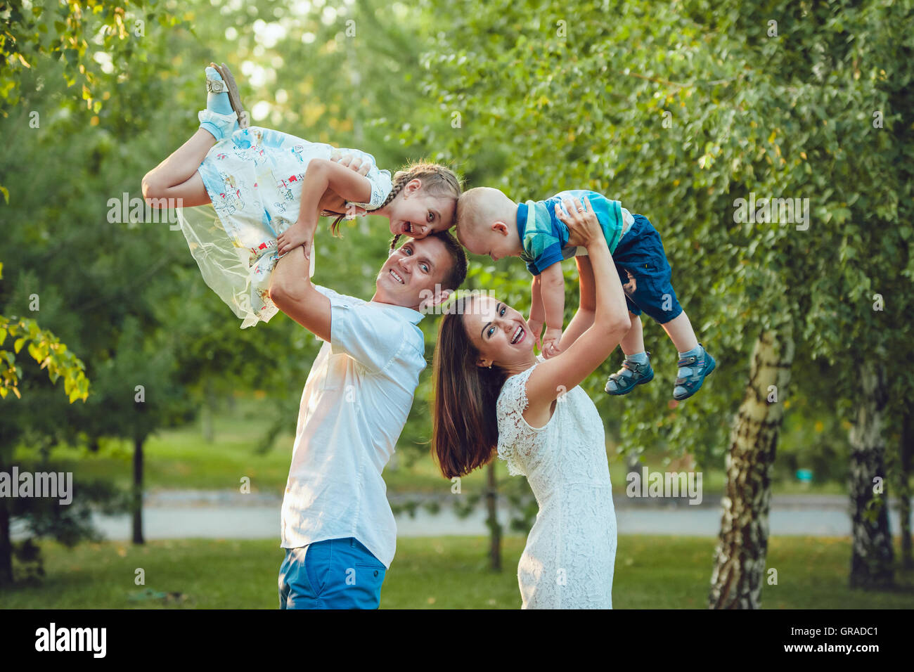 Young family of four having fun in the park Stock Photo - Alamy