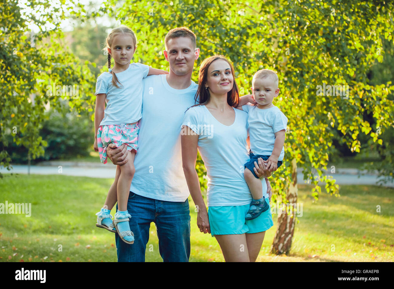 Portrait of young happy ypung family walking in sunny park Stock Photo ...
