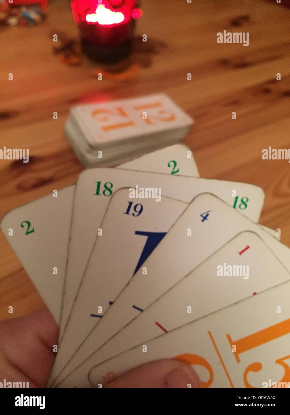 Cropped Image Of Hand Holding Playing Cards Over Table Stock Photo - Alamy
