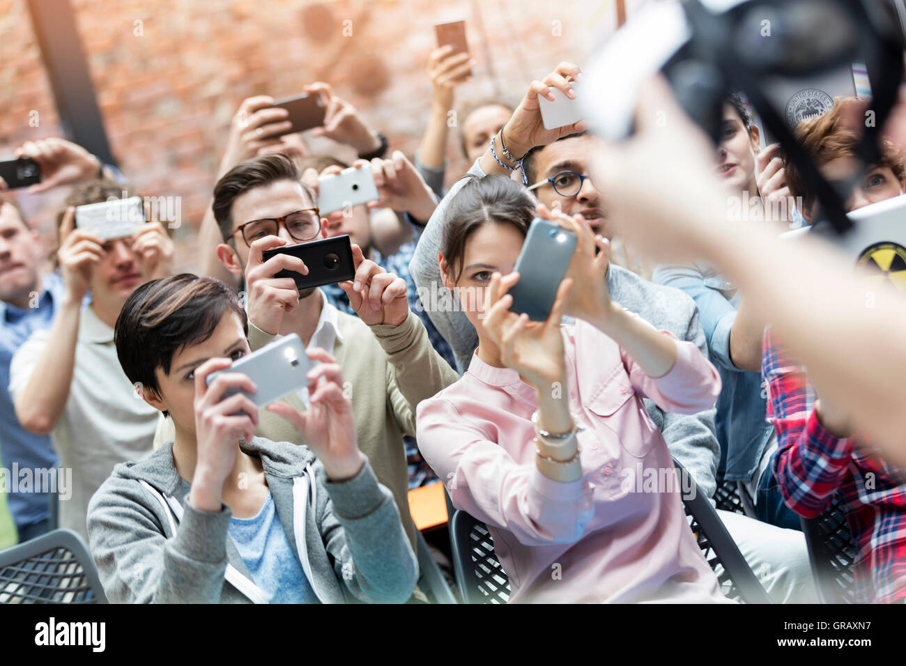 Audience using camera phones at technology conference Stock Photo - Alamy
