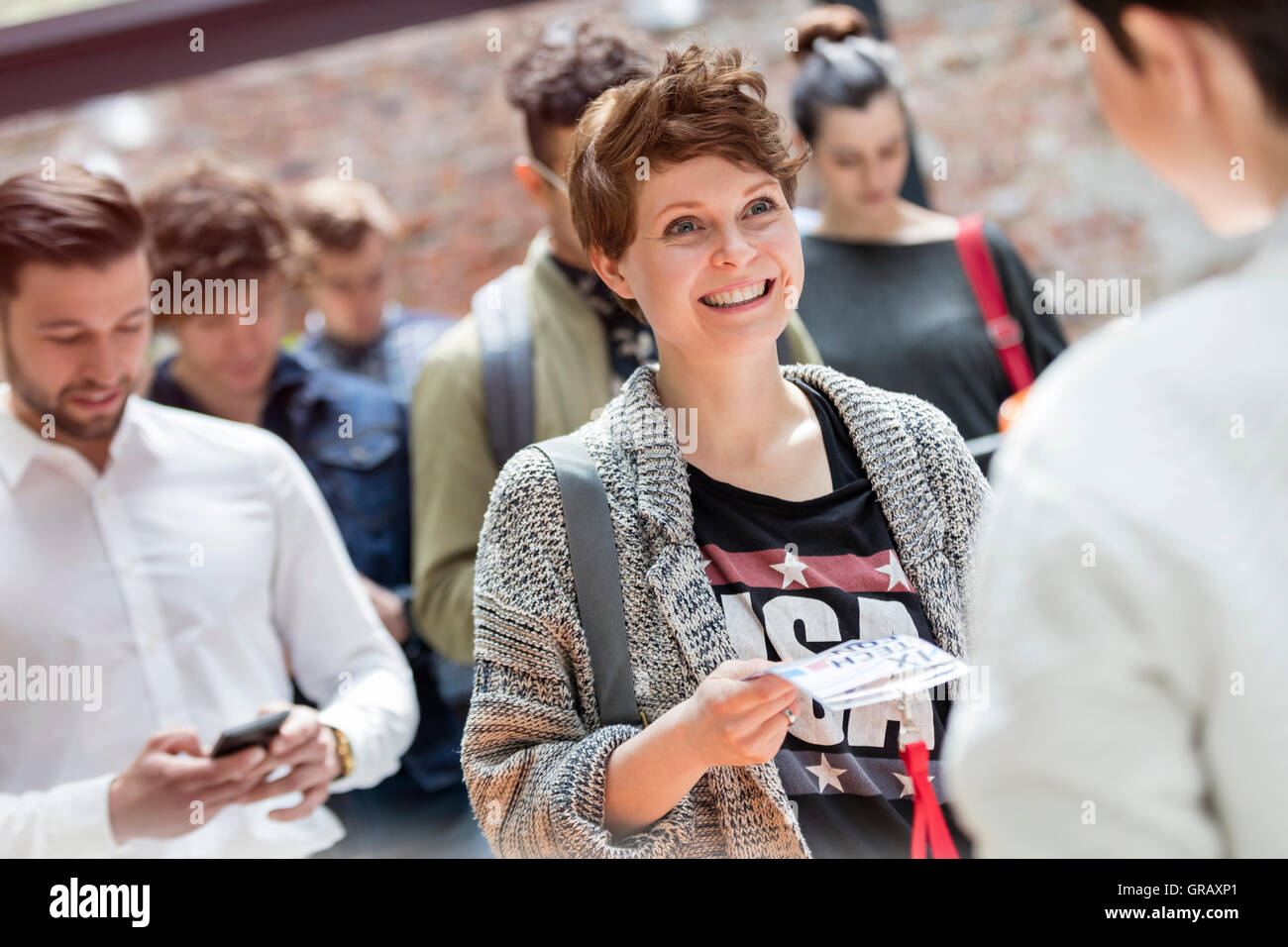 Smiling young woman showing credentials at technology conference Stock ...