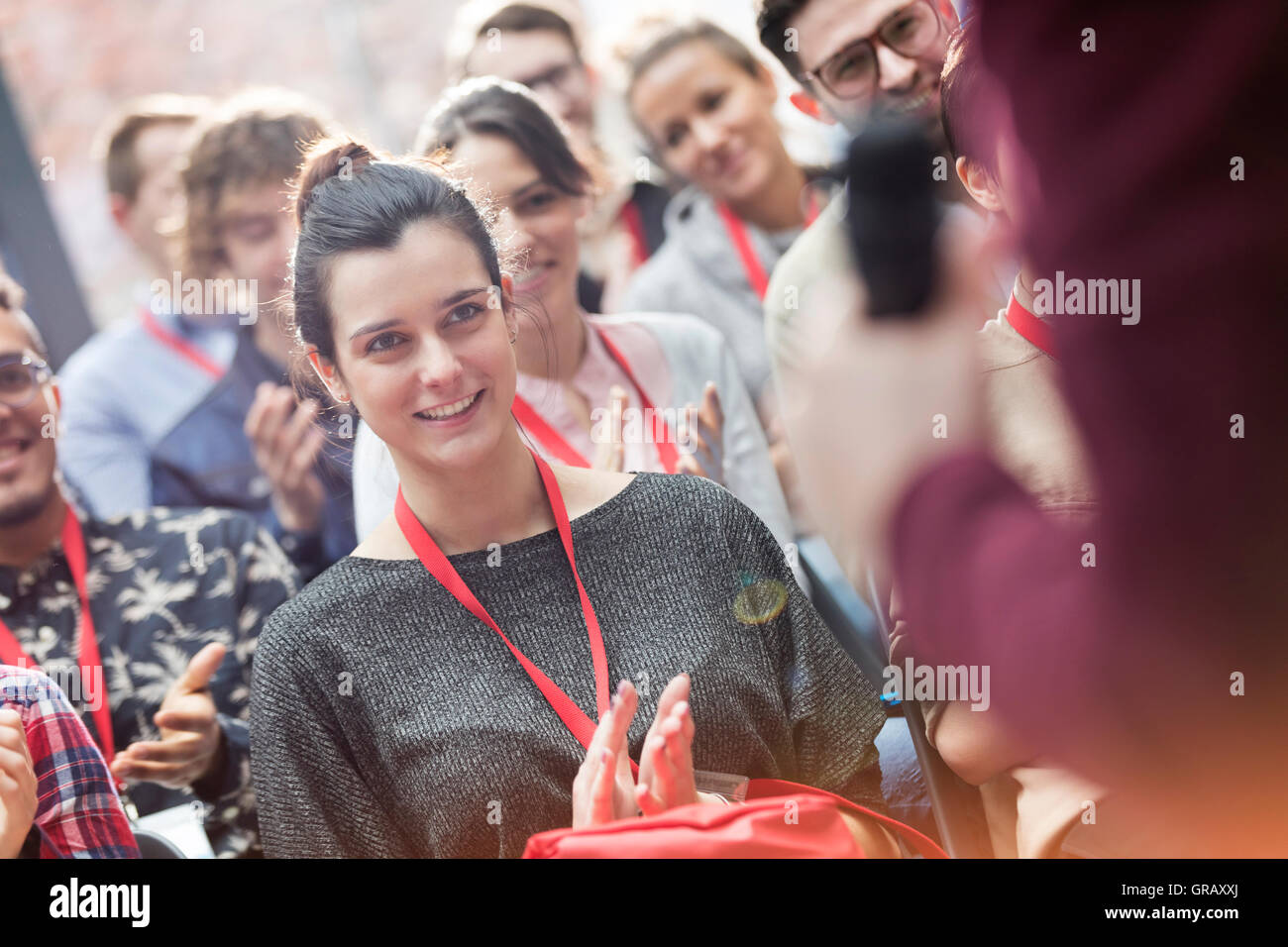 Smiling woman in audience clapping at conference Stock Photo - Alamy