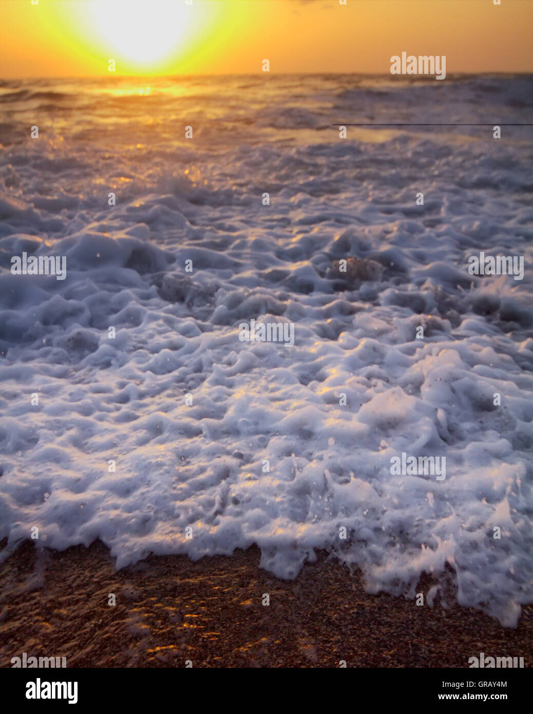 Gentle warm sea on backdrop of enchanting sunset. Foamy surf ...