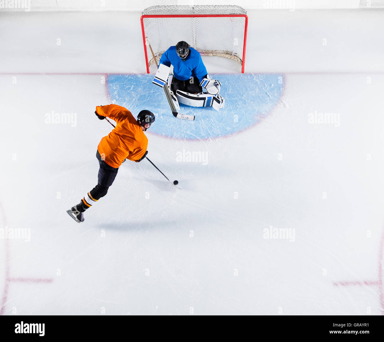 Hockey player shooting the puck at goal net Stock Photo - Alamy