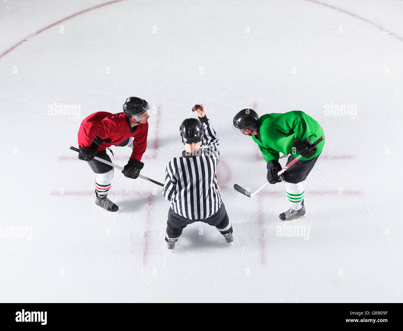 Hockey referee initiating opening face off between opponents Stock ...