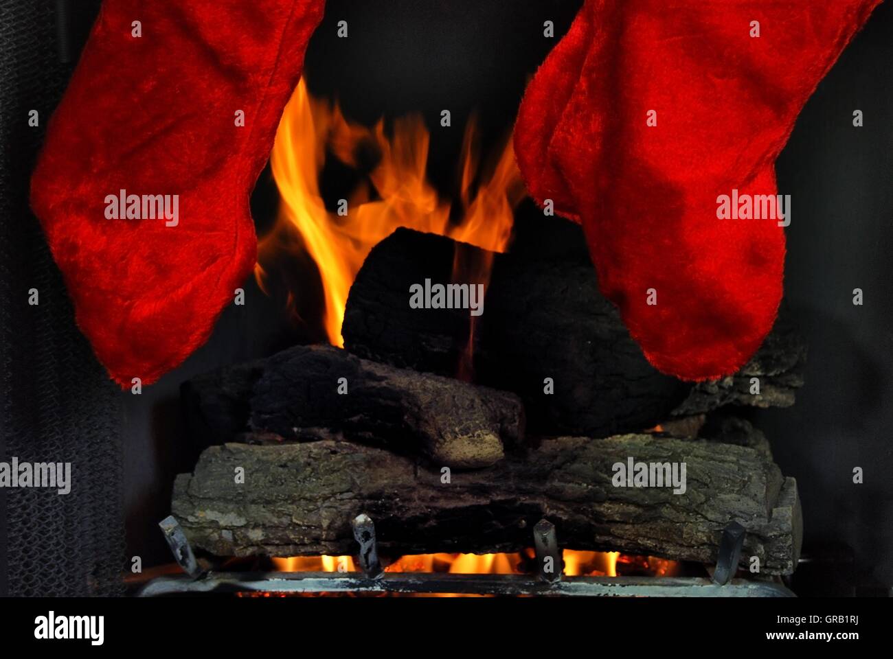 red furry Christmas stocking hanging on fireplace with fire Stock Photo ...
