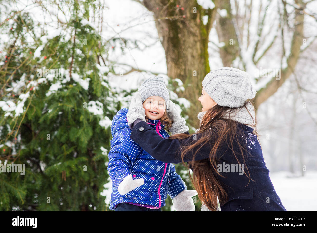 Mother with her daughter playing outside in winter nature Stock Photo ...