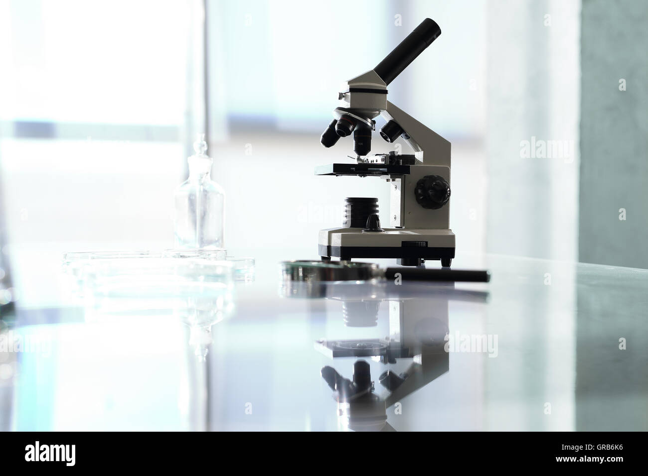Workshop laboratory microscope stands on a glass countertop Stock Photo ...