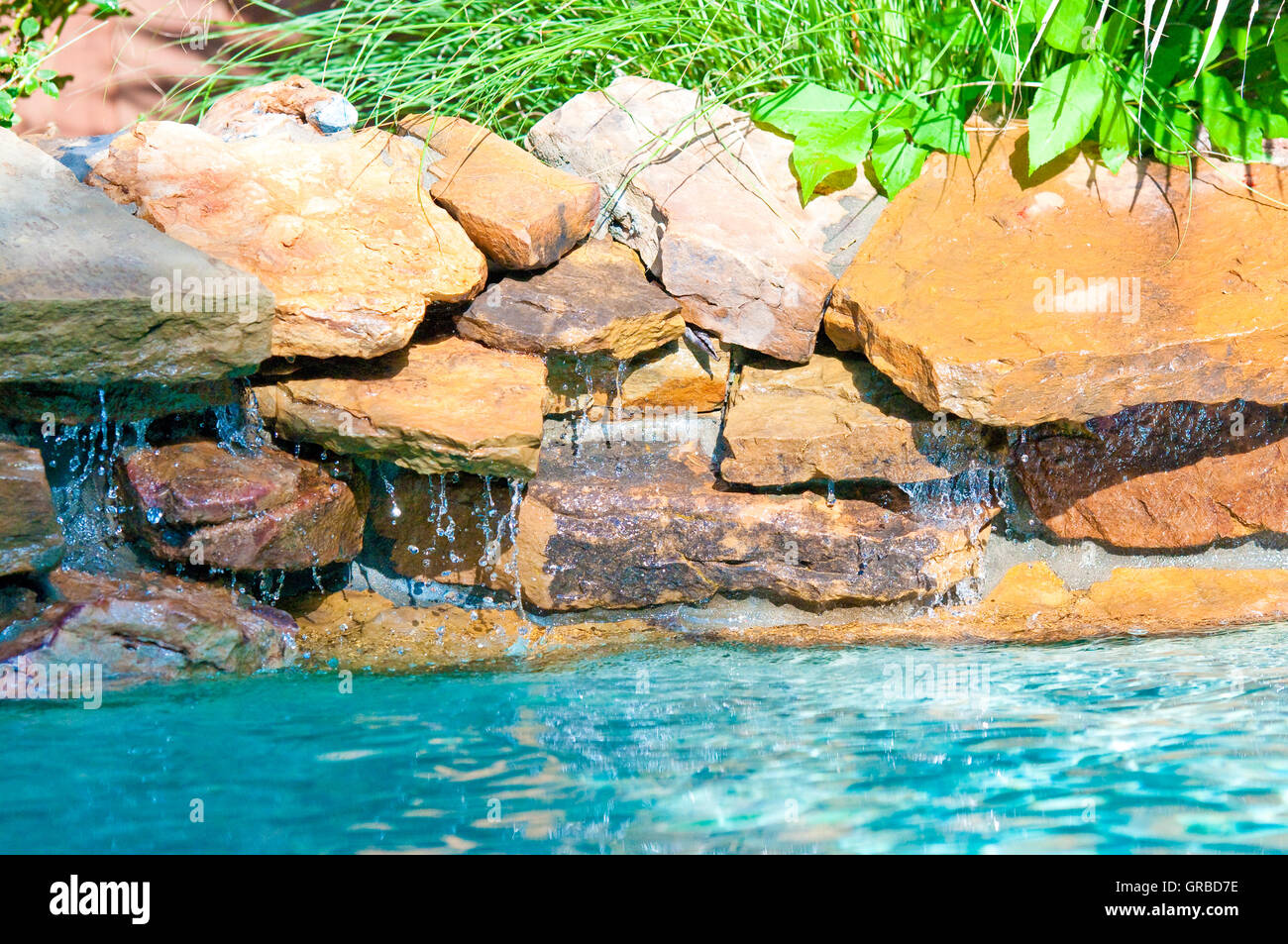 waterfall falling in a blue swimming pool Stock Photo - Alamy