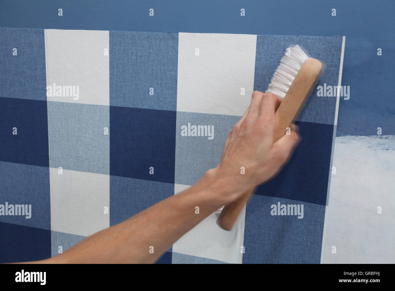 decorator hanging wallpaper with work tool in motion Stock Photo - Alamy
