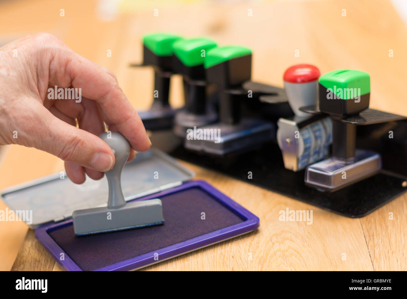 Presses Stamp In Stamp Pad, Behind Another Stamp On Stamp Holder Stock ...